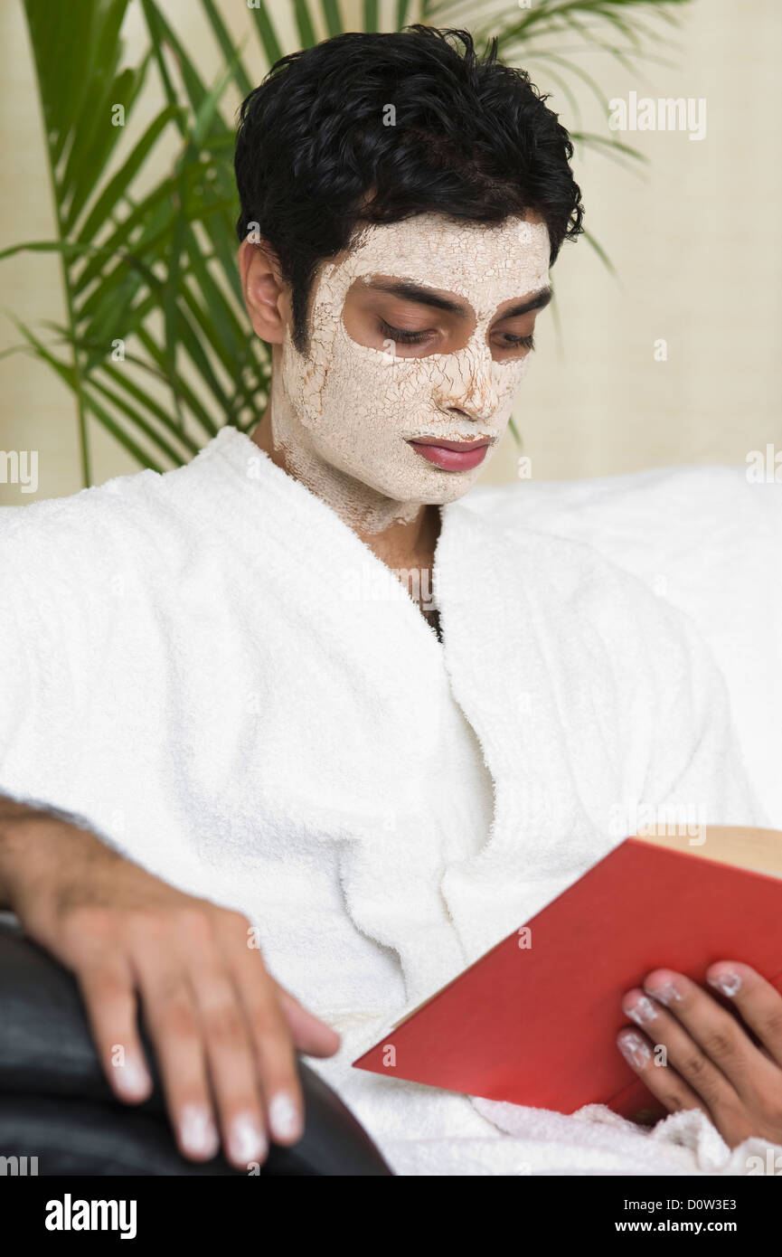 Man with facial mask reading a book Stock Photo - Alamy
