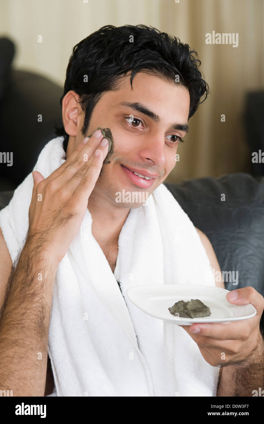 Close-up of a man applying mud pack on his face Stock Photo - Alamy