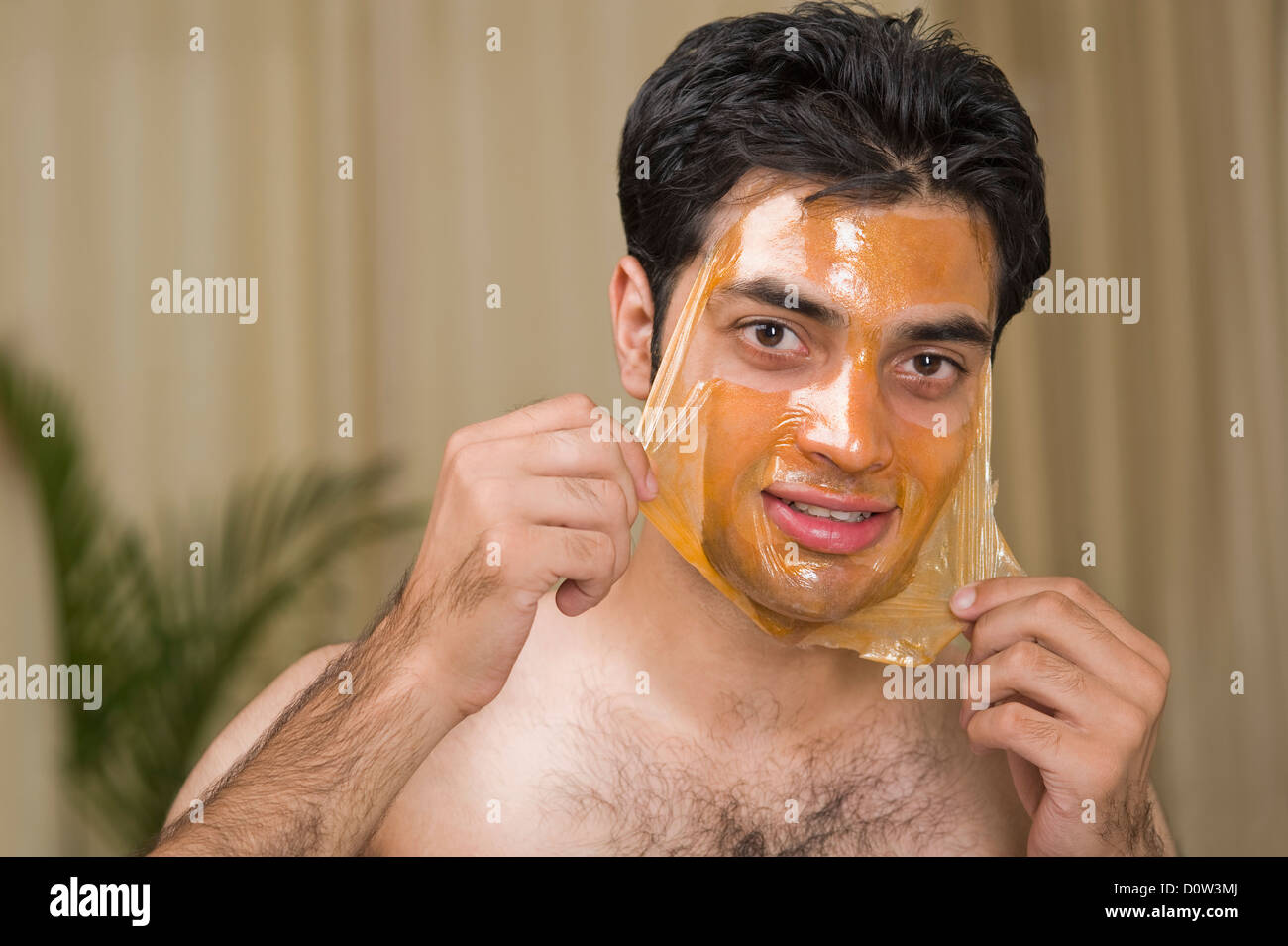 Portrait of a man peeling off facial mask from face Stock Photo - Alamy