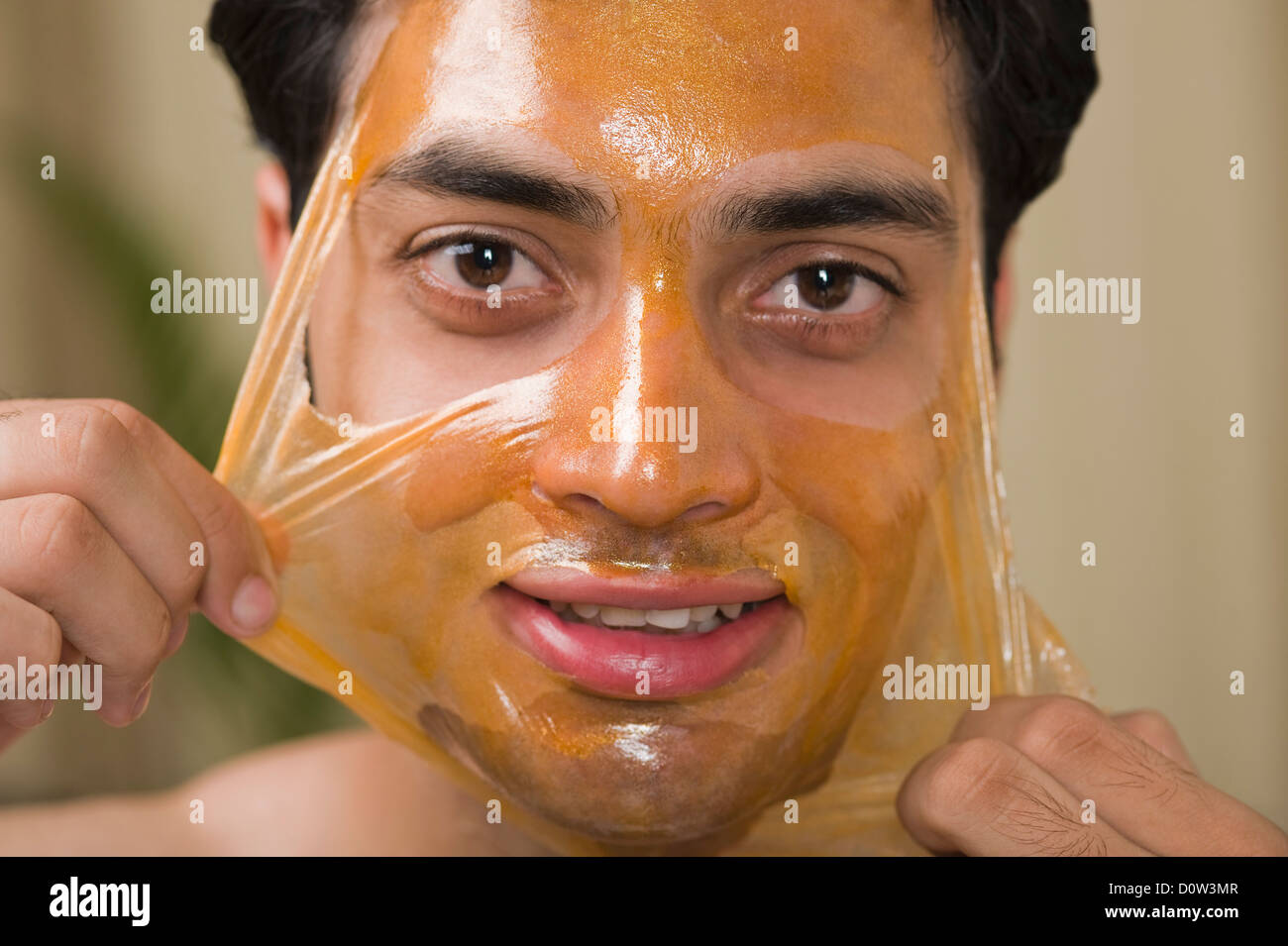 Portrait of a man peeling off facial mask from face Stock Photo - Alamy