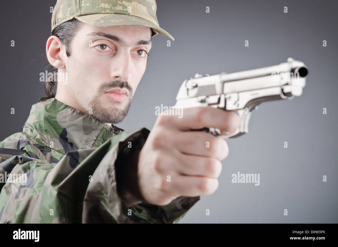 Soldier with gun in studio shooting Stock Photo - Alamy