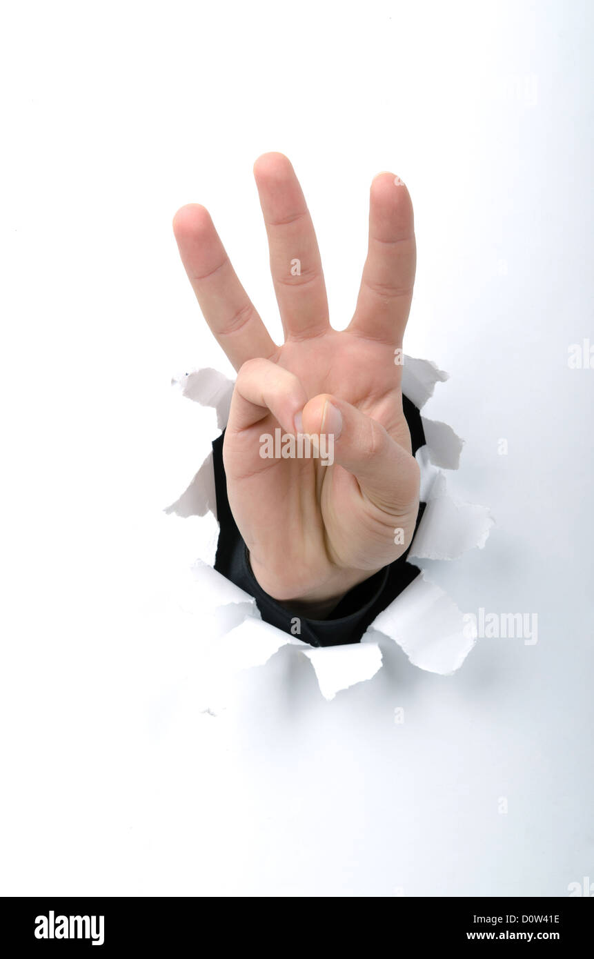 Hand through the hole in paper Stock Photo - Alamy