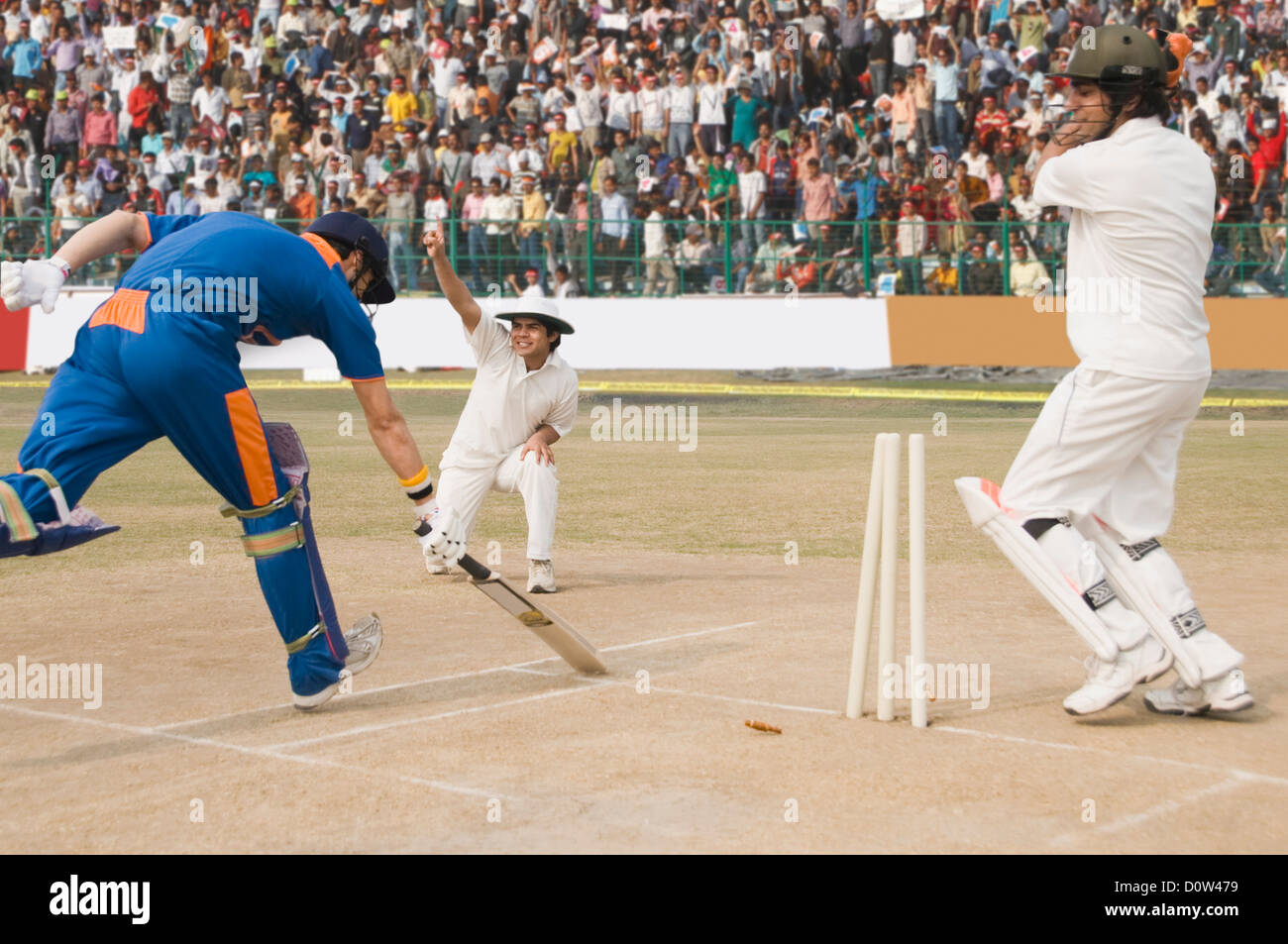 Cricket batsman scoring a run and fielder appealing for run out Stock ...