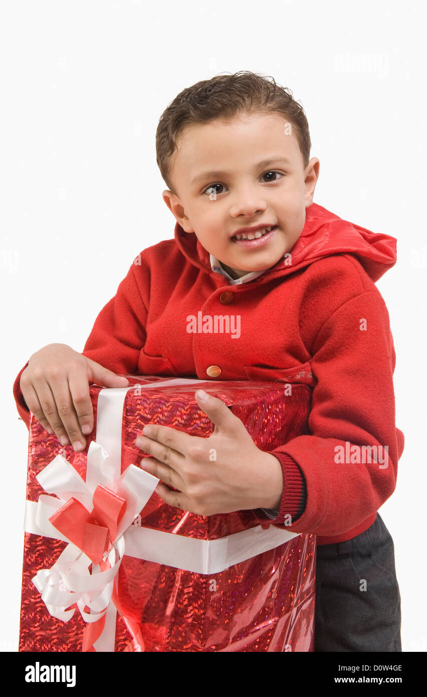 Boy holding a present and smiling Stock Photo - Alamy
