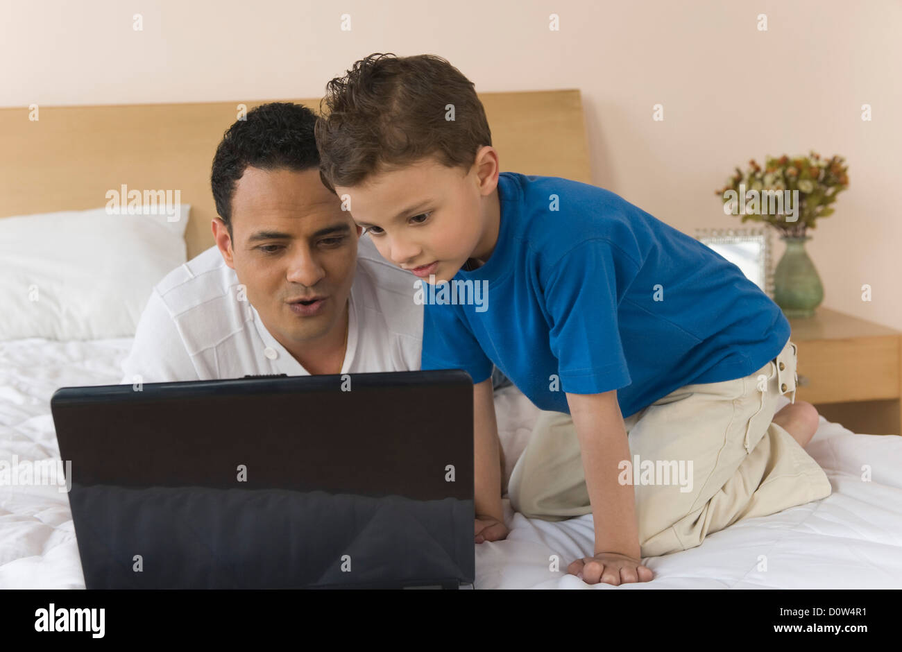 Man and his son using a laptop Stock Photo - Alamy