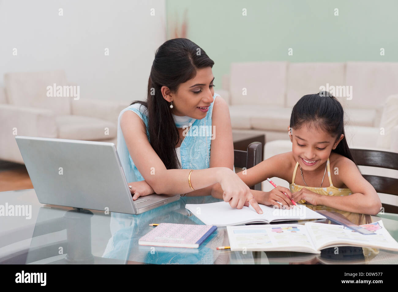 Woman helping her daughter in studies Stock Photo - Alamy