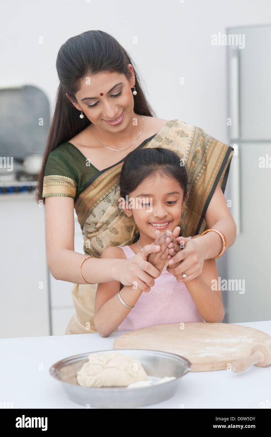 Girl learning cooking with the help of her mother Stock Photo - Alamy
