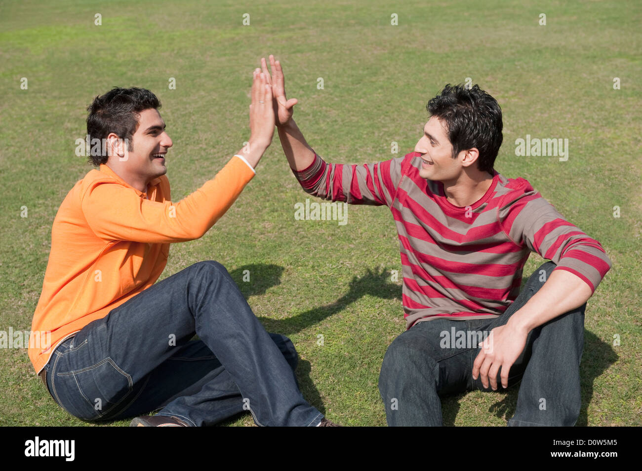 Friends giving high-five to each other Stock Photo - Alamy