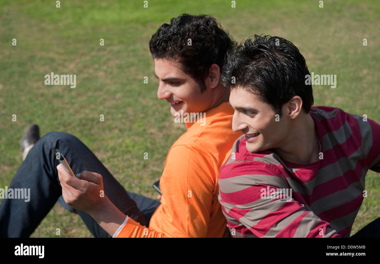 Smiling man sending message to friends hi-res stock photography and ...