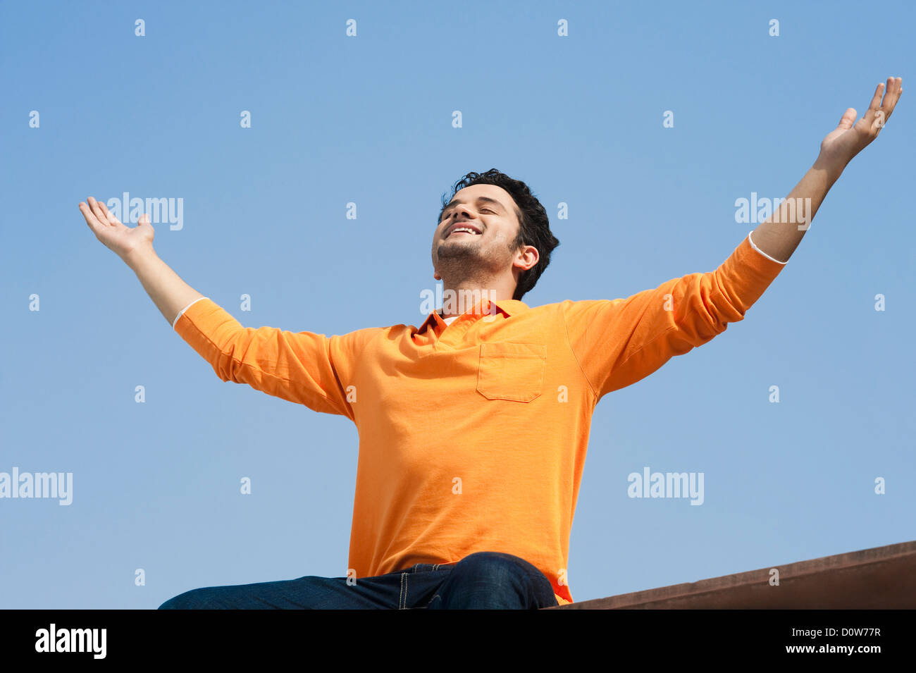 Man sitting with his arm outstretched Stock Photo - Alamy