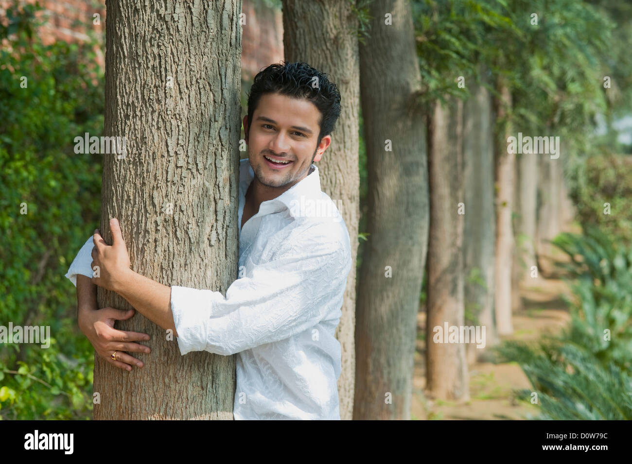 Man hugging a tree and smiling Stock Photo - Alamy