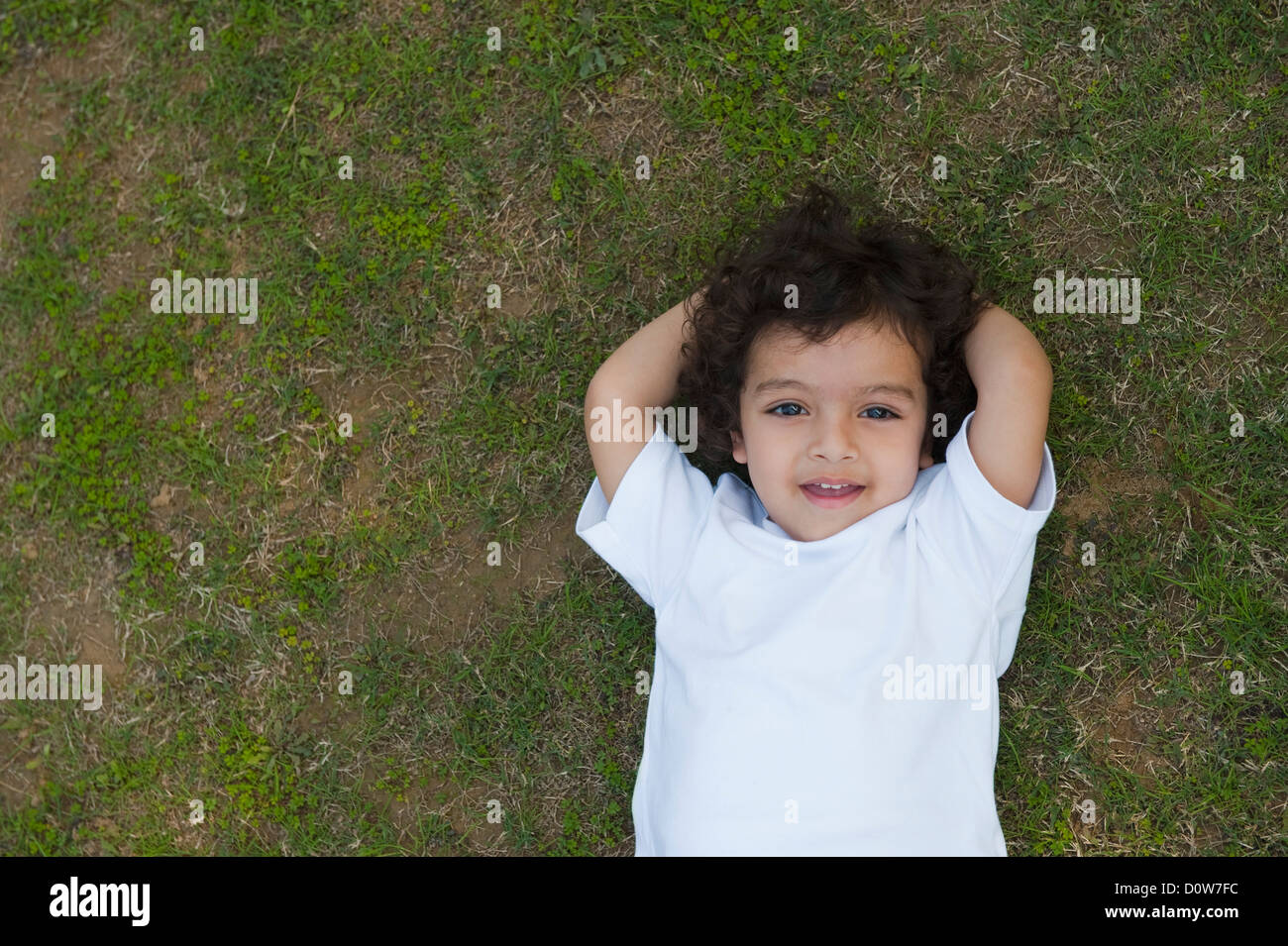 Boy lying on grass Stock Photo - Alamy