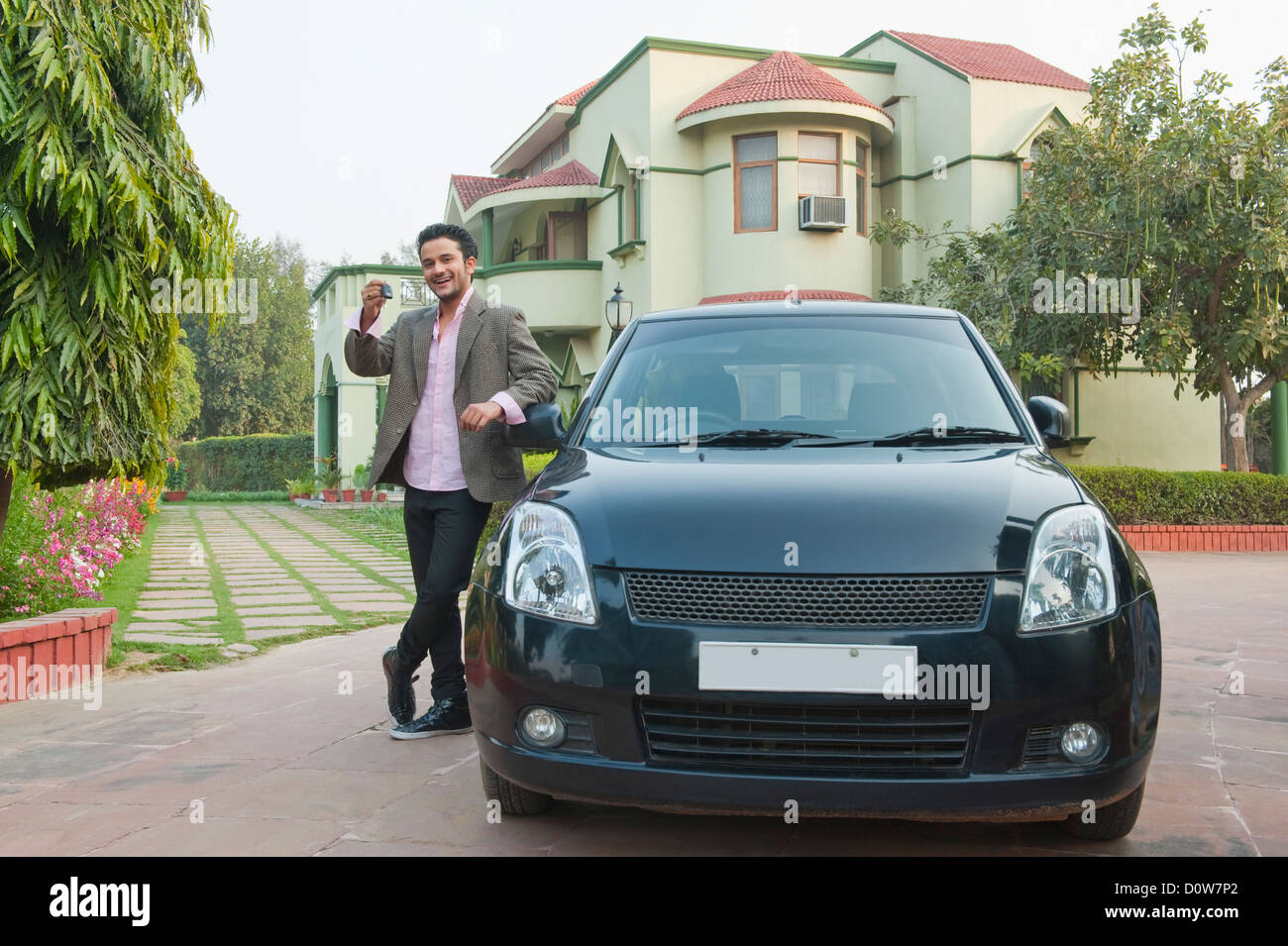 Man standing beside his new car and showing car key Stock Photo - Alamy