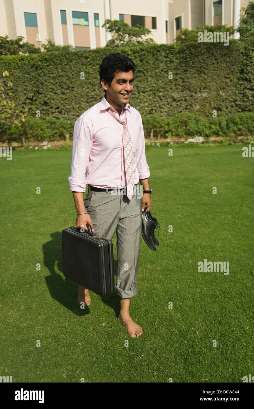 Businessman walking barefoot in a park, Gurgaon, Haryana, India Stock ...
