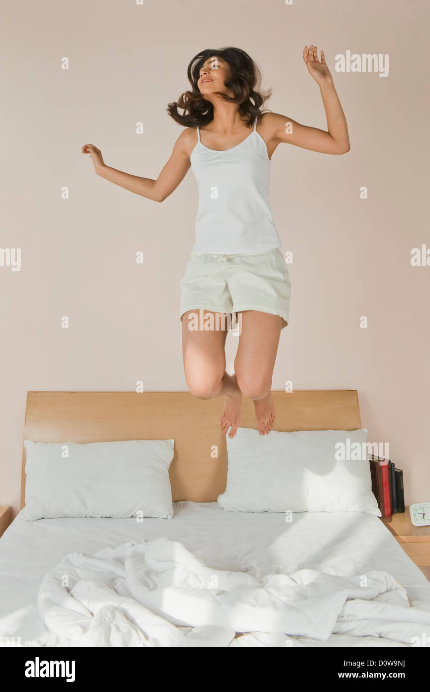Woman jumping on the bed Stock Photo - Alamy