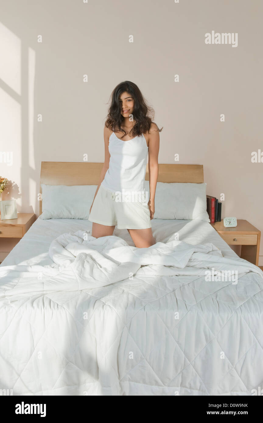 Portrait of a woman kneeling on the bed Stock Photo - Alamy