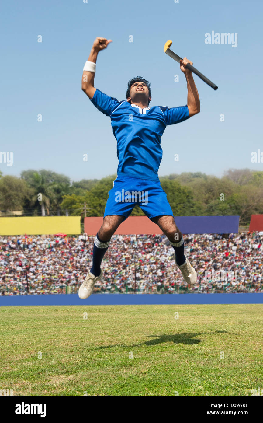 Hockey player jumping in excitement in a field Stock Photo - Alamy