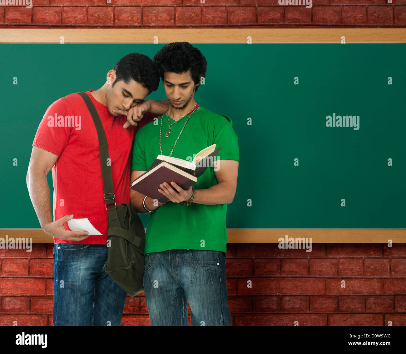 University student looking at a photograph beside his friend in a ...