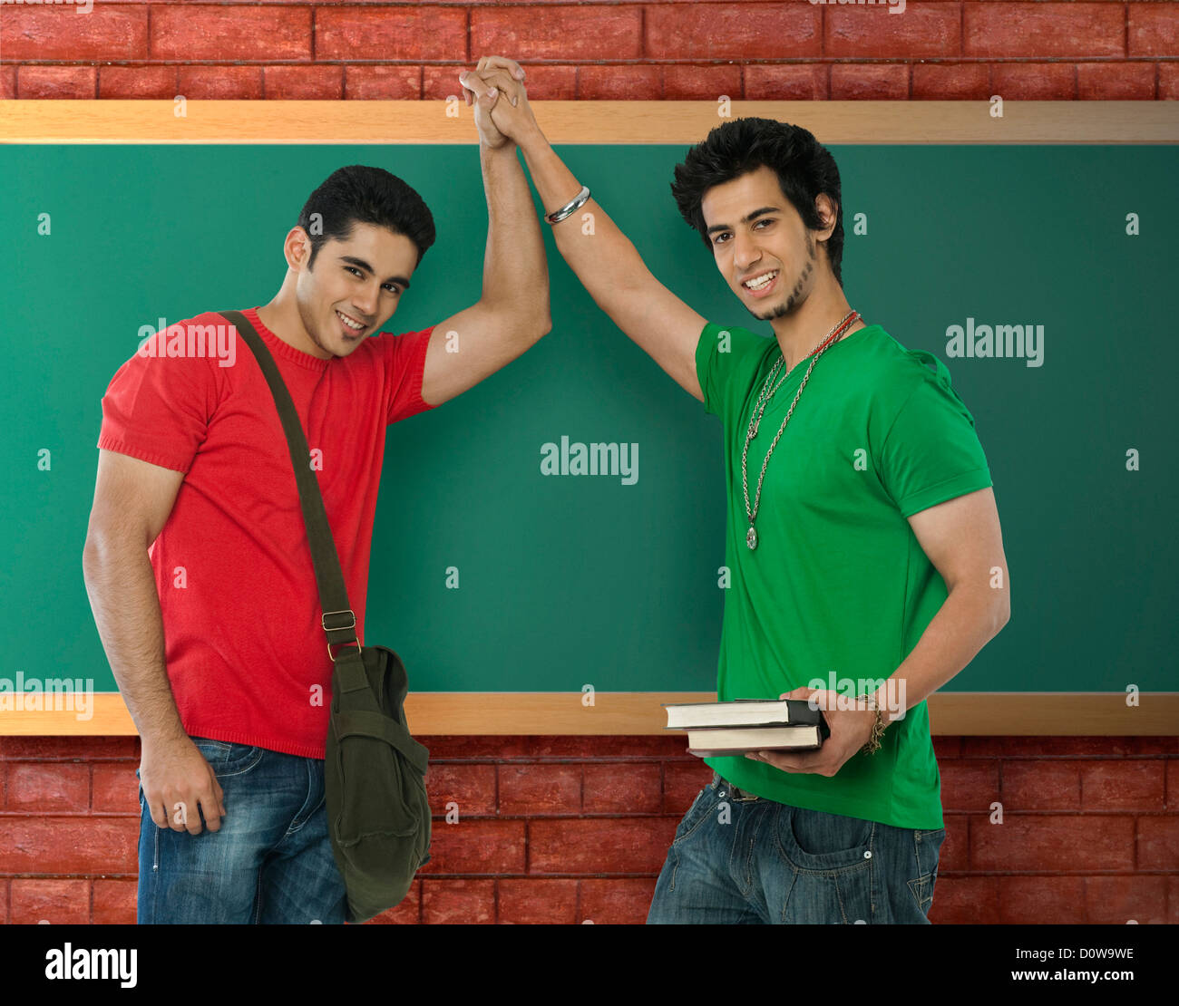 Portrait of two university students smiling with their hands clasped ...