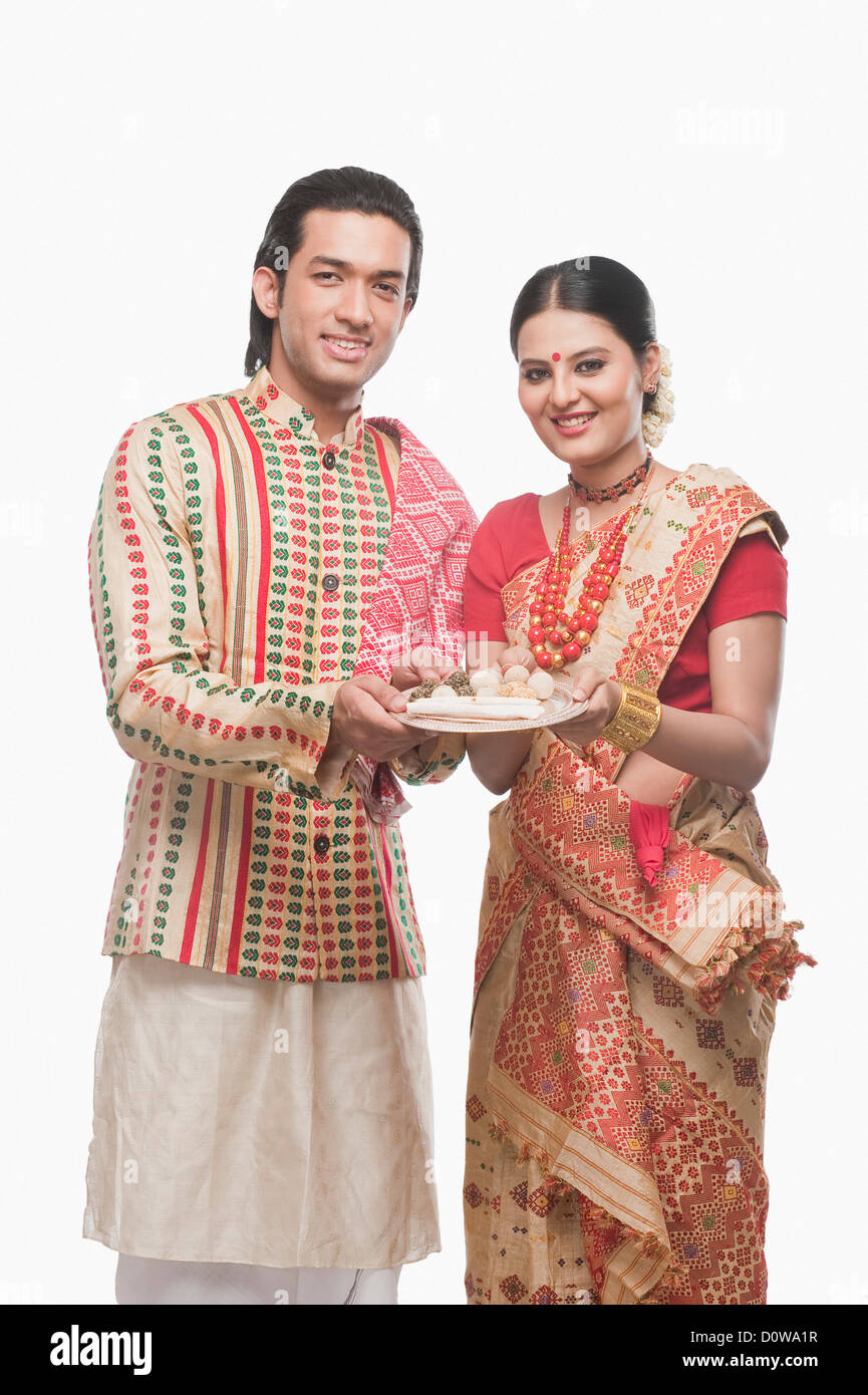 Portrait of a couple holding a plate of religious offerings Stock Photo ...