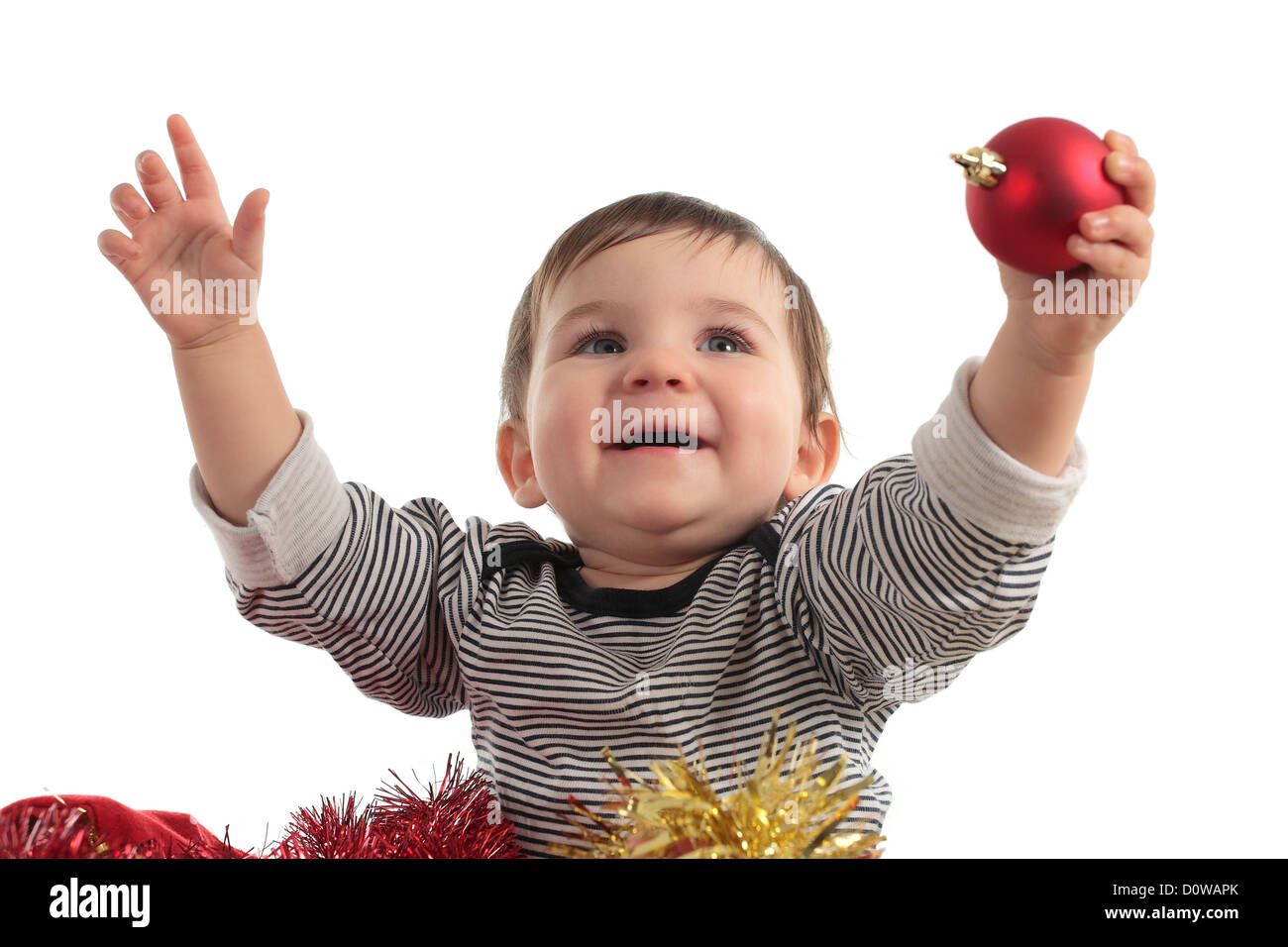 Eight months baby inside a box showing a christmas ball in a white ...