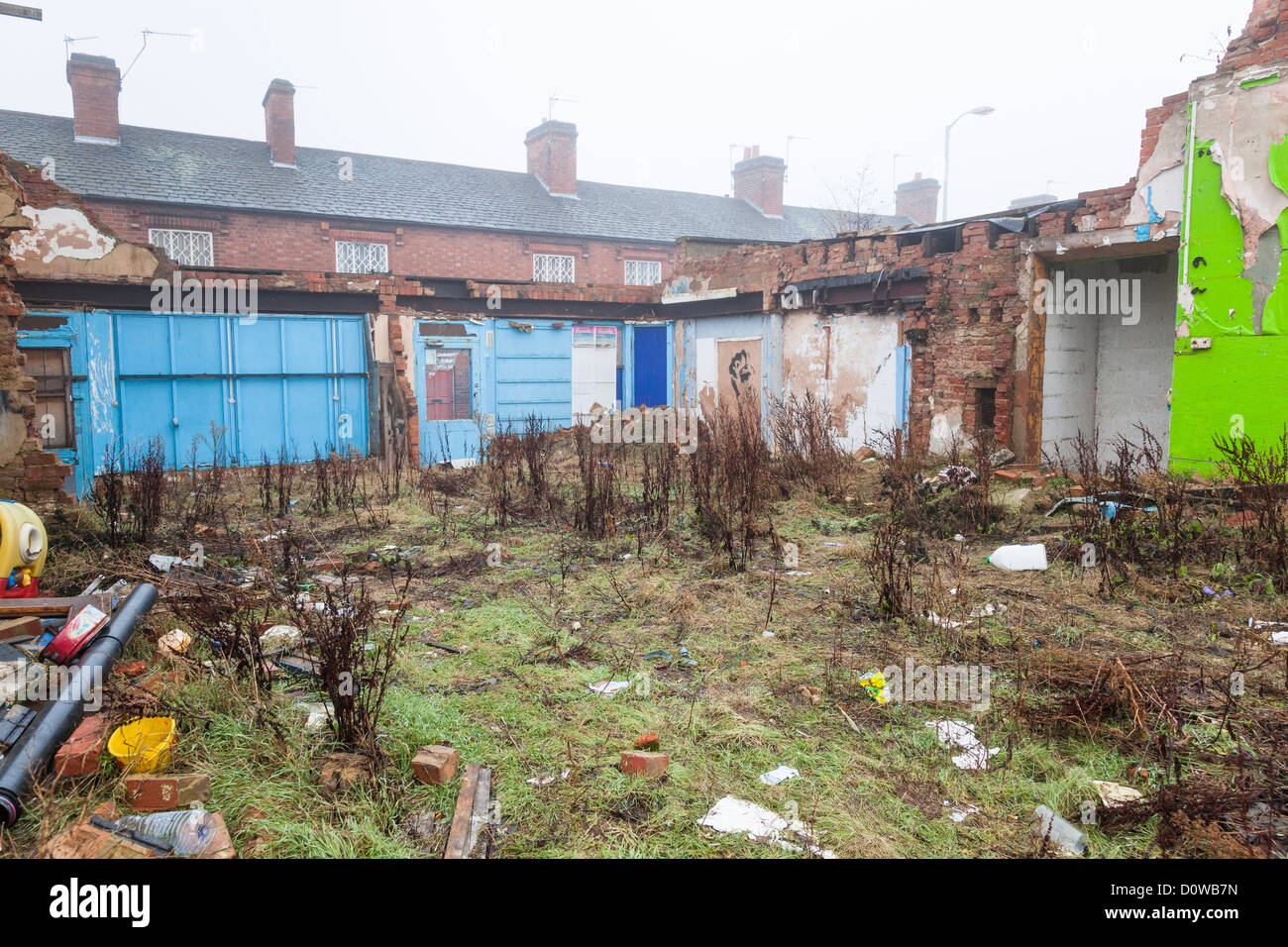 Derelict and abandoned area with rubbish and weeds and a backdrop of ...