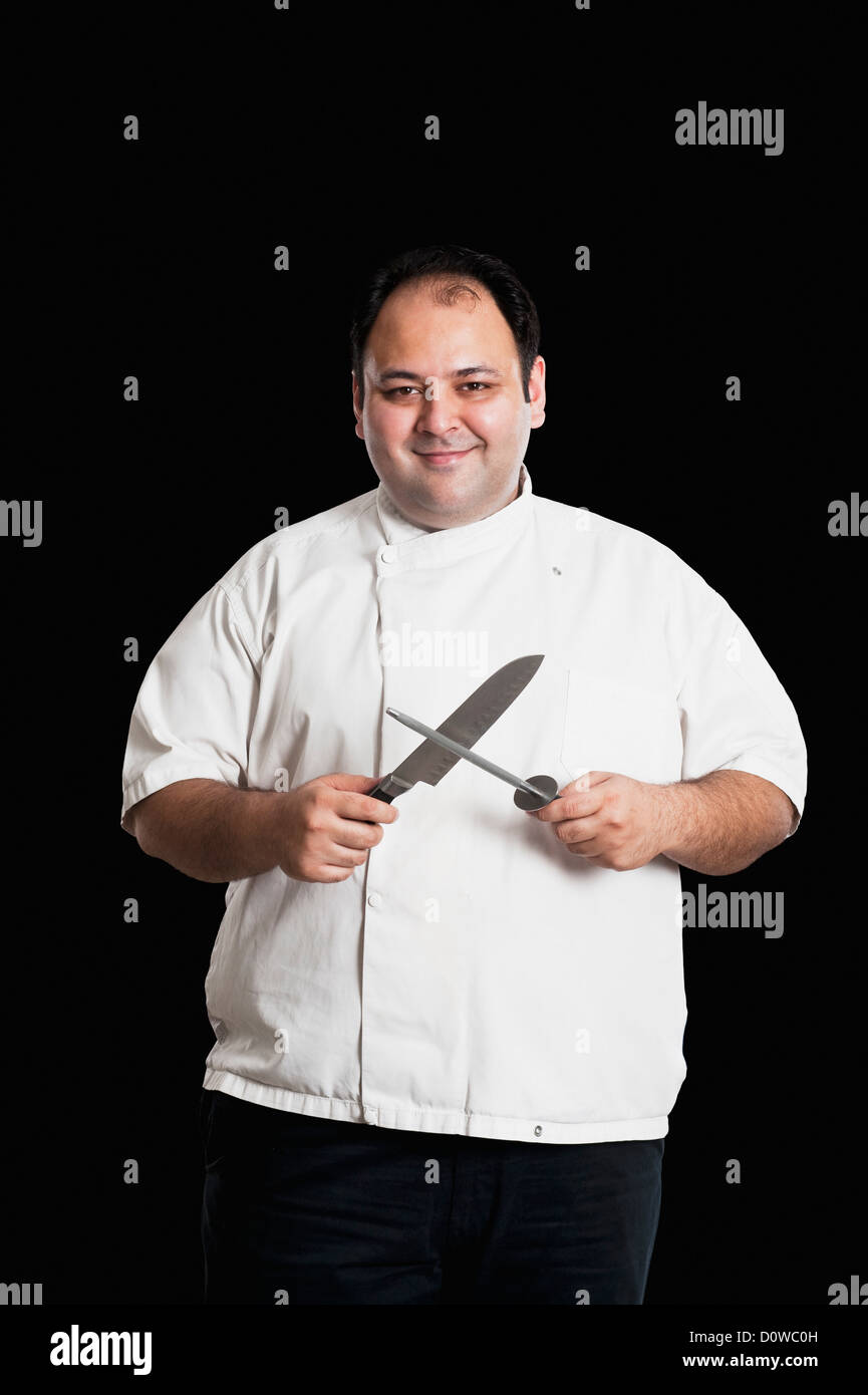 Portrait of a chef sharpening knives Stock Photo - Alamy