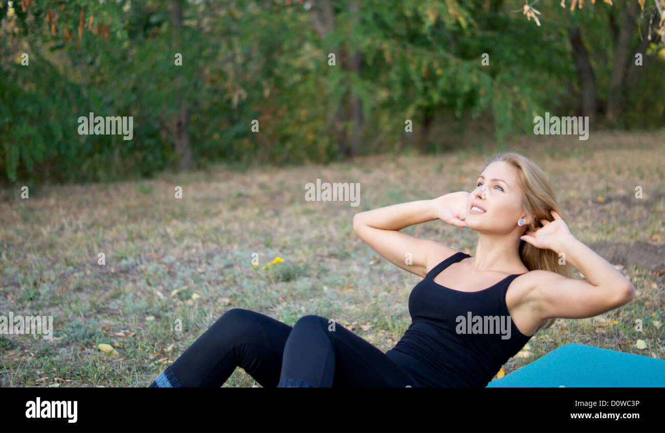 Athletic woman doing sit-ups to flex and strengthen her abdominal ...