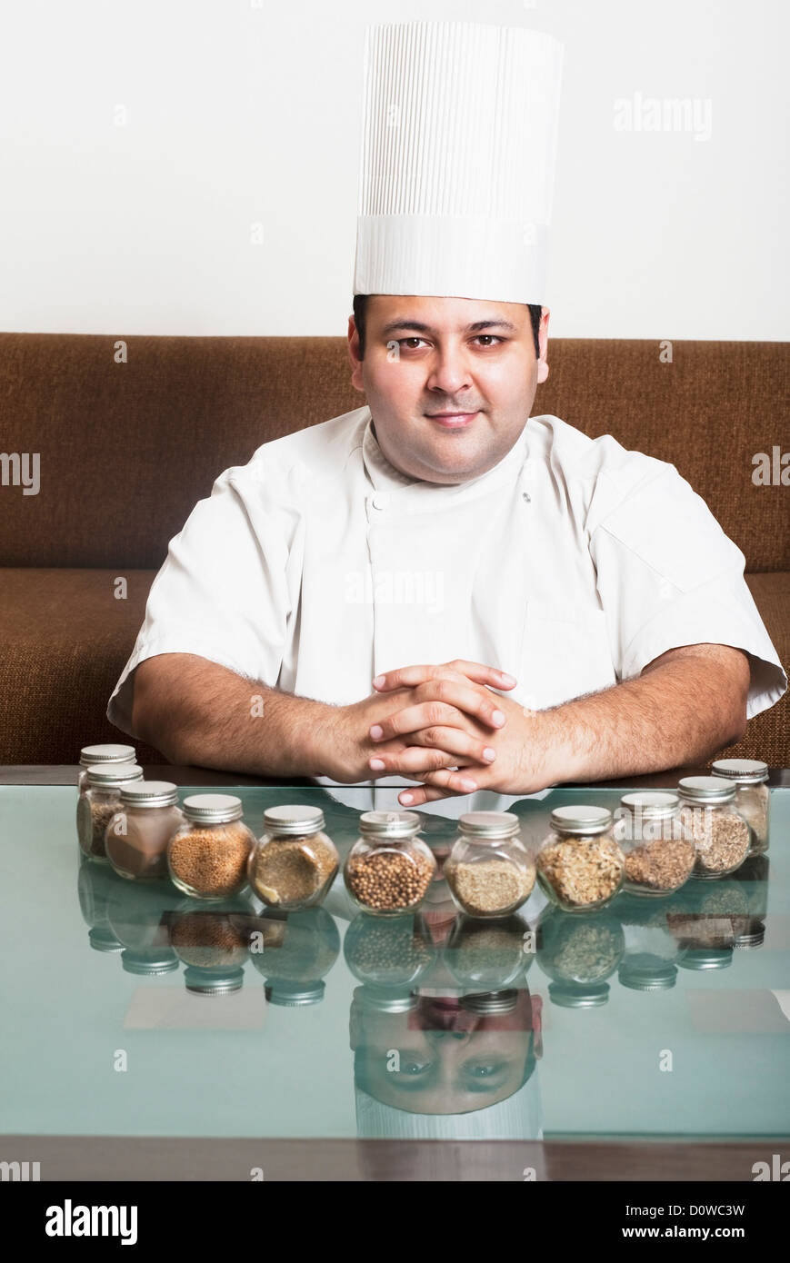 Chef smiling with assorted spices on a table, Gurgaon, Haryana, India ...