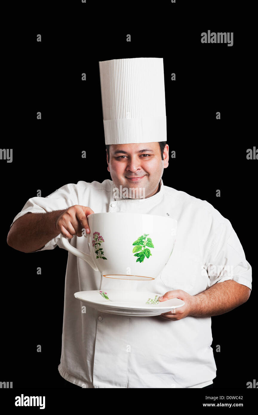 Chef drinking from an oversized cup Stock Photo - Alamy