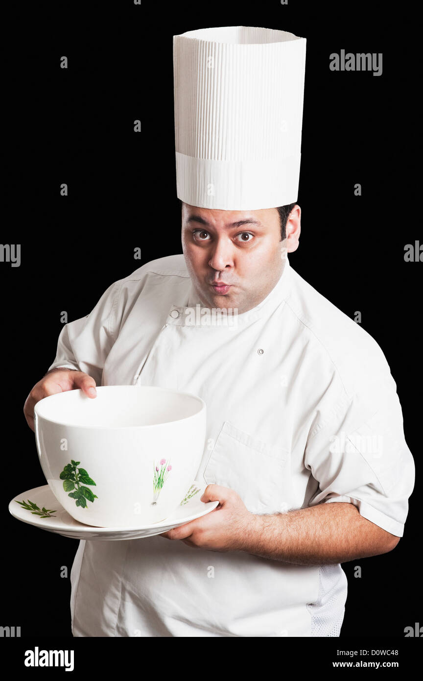 Chef holding an oversized cup Stock Photo - Alamy