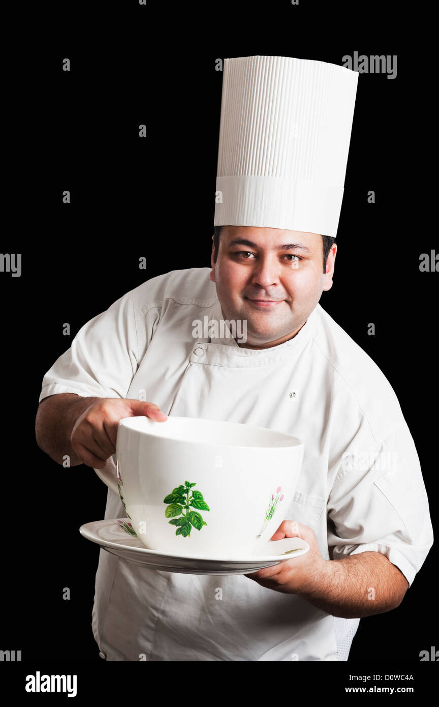 Chef holding an oversized cup Stock Photo - Alamy