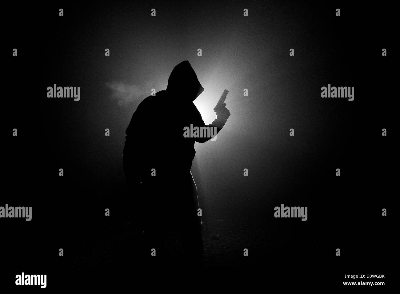 Foggy Night Shooter: Dark silhouette of a hooded man holding a semi ...
