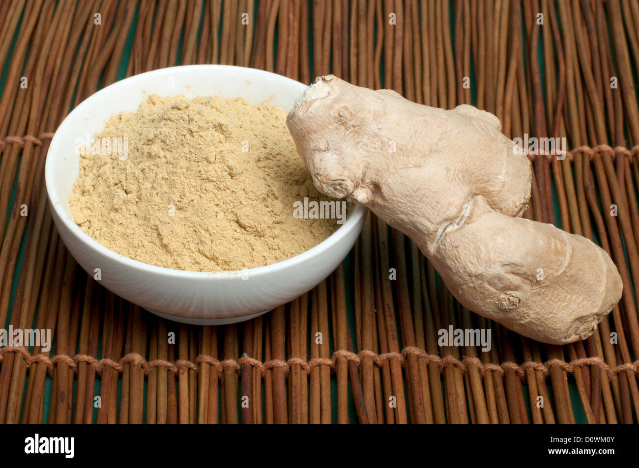 Powdered ginger in a bowl and whole ginger on wooden base Stock Photo ...