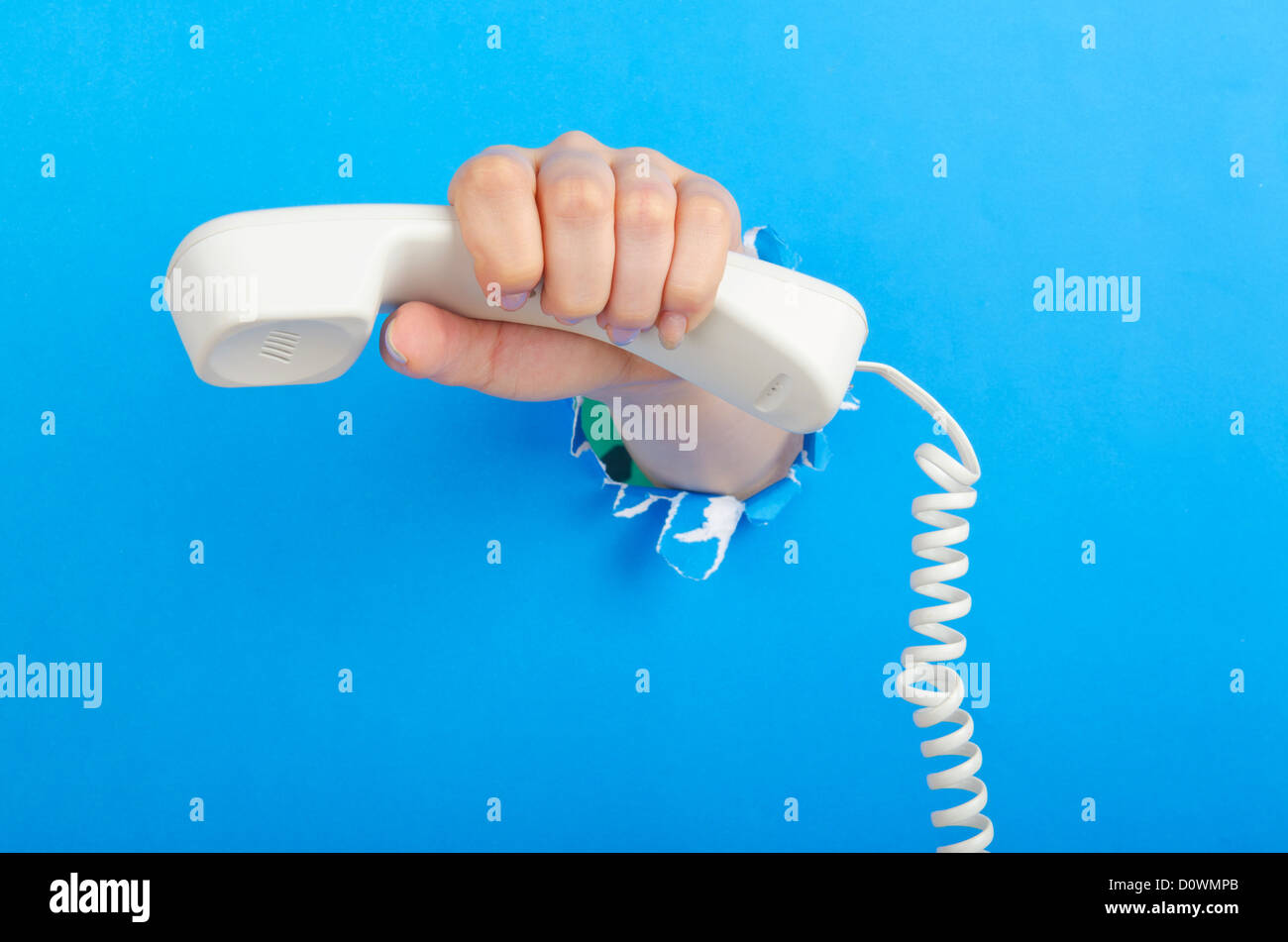 Hand with phone out of paper hole Stock Photo - Alamy