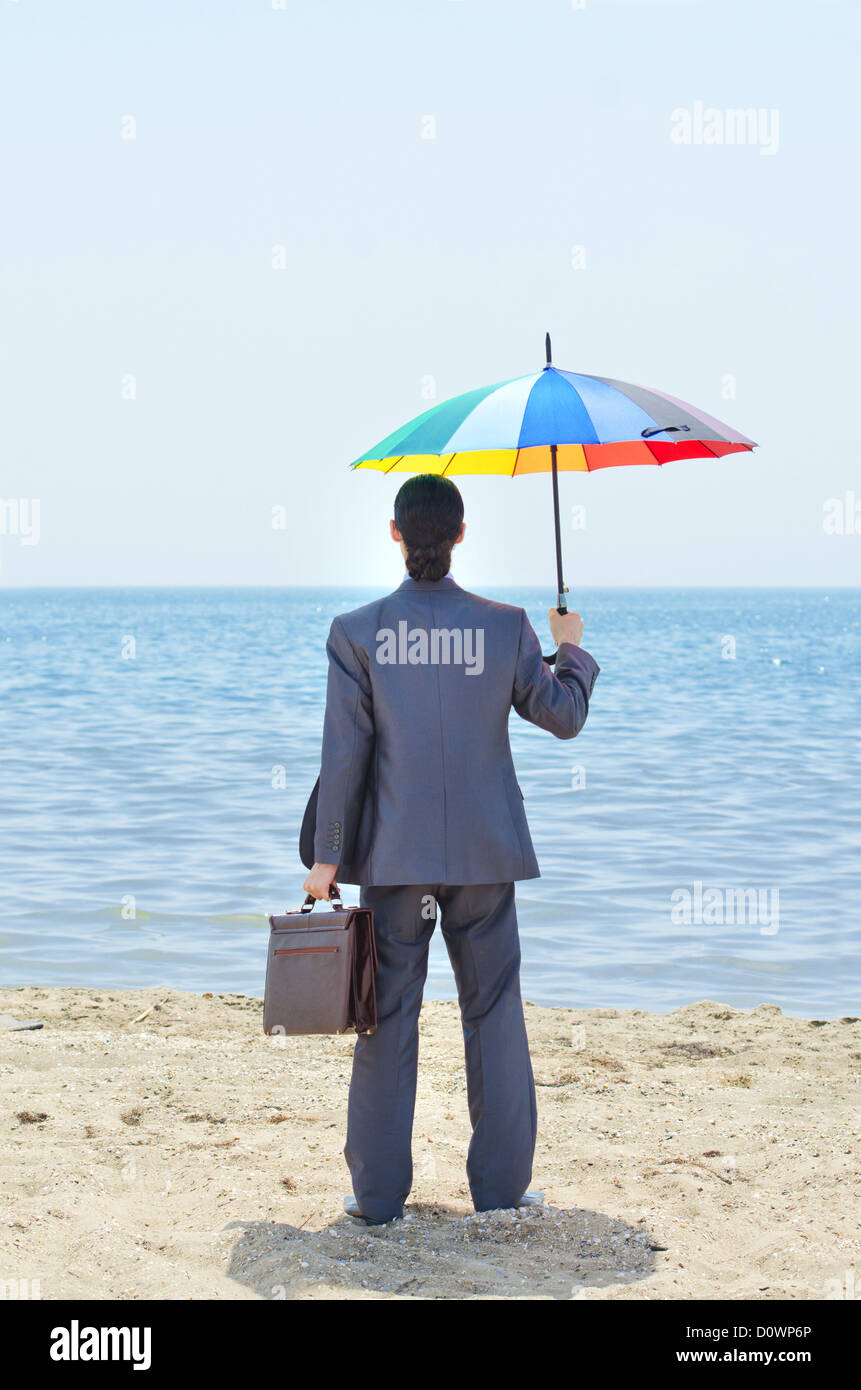 Man with umbrella on beach Stock Photo - Alamy