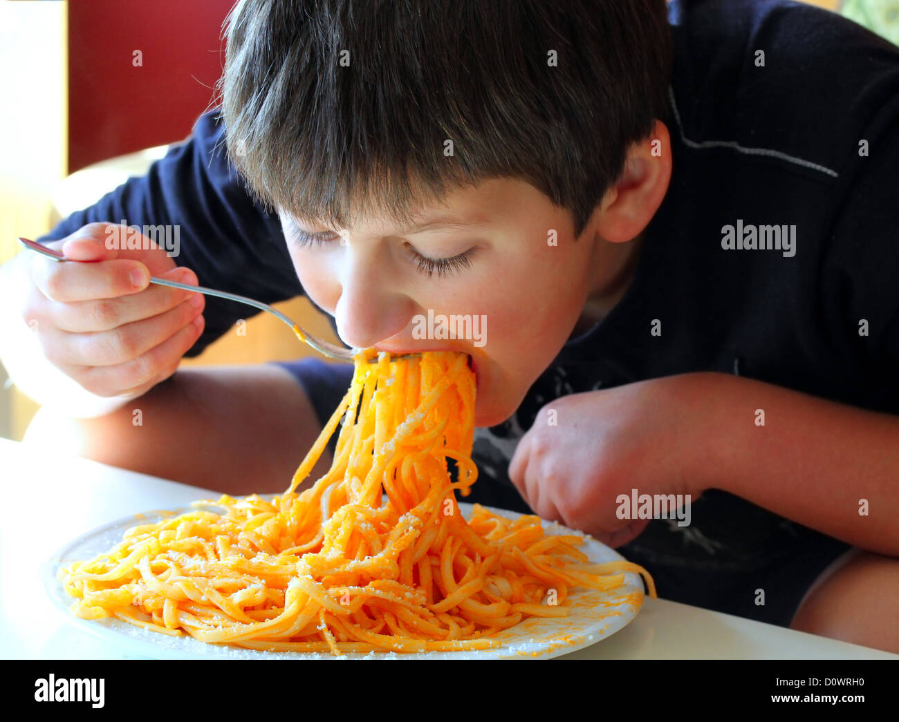 Boy eating spaghetti Stock Photo - Alamy