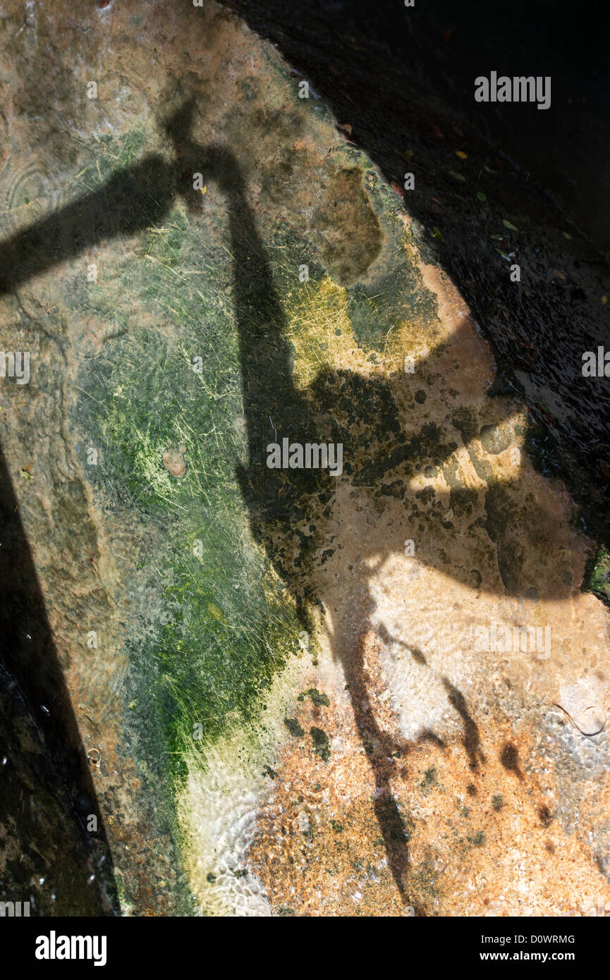 Shadow of an Indian girl washing hands at a communal water tap in rural ...