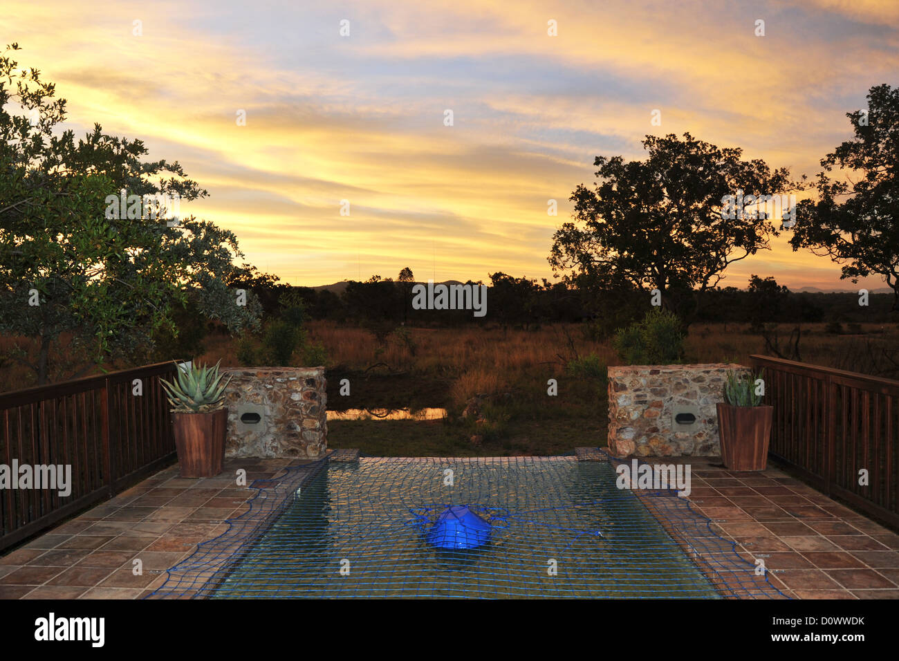 A private swimming pool with a dramatic South African sunset behind it ...