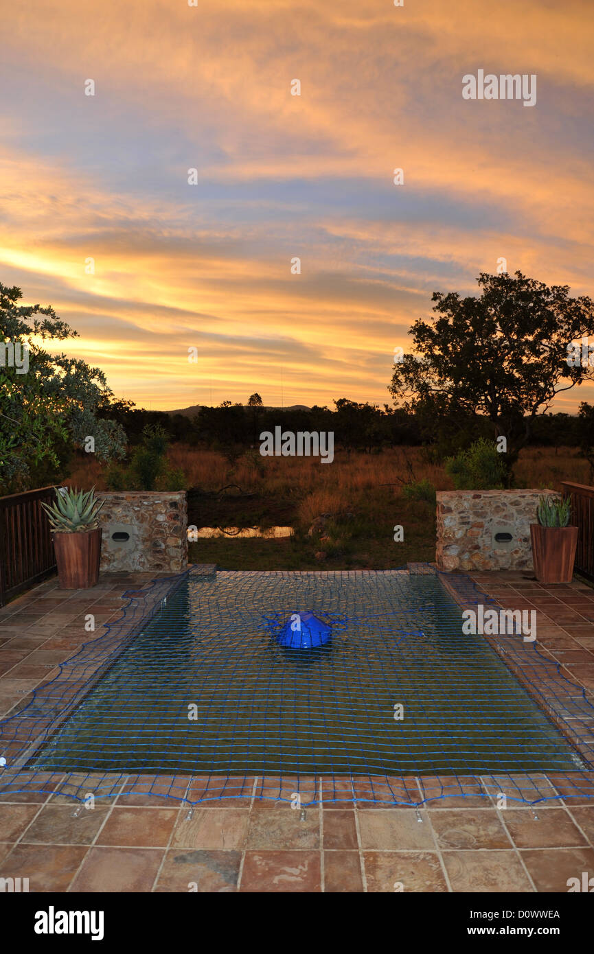 A private swimming pool with a dramatic South African sunset behind it ...
