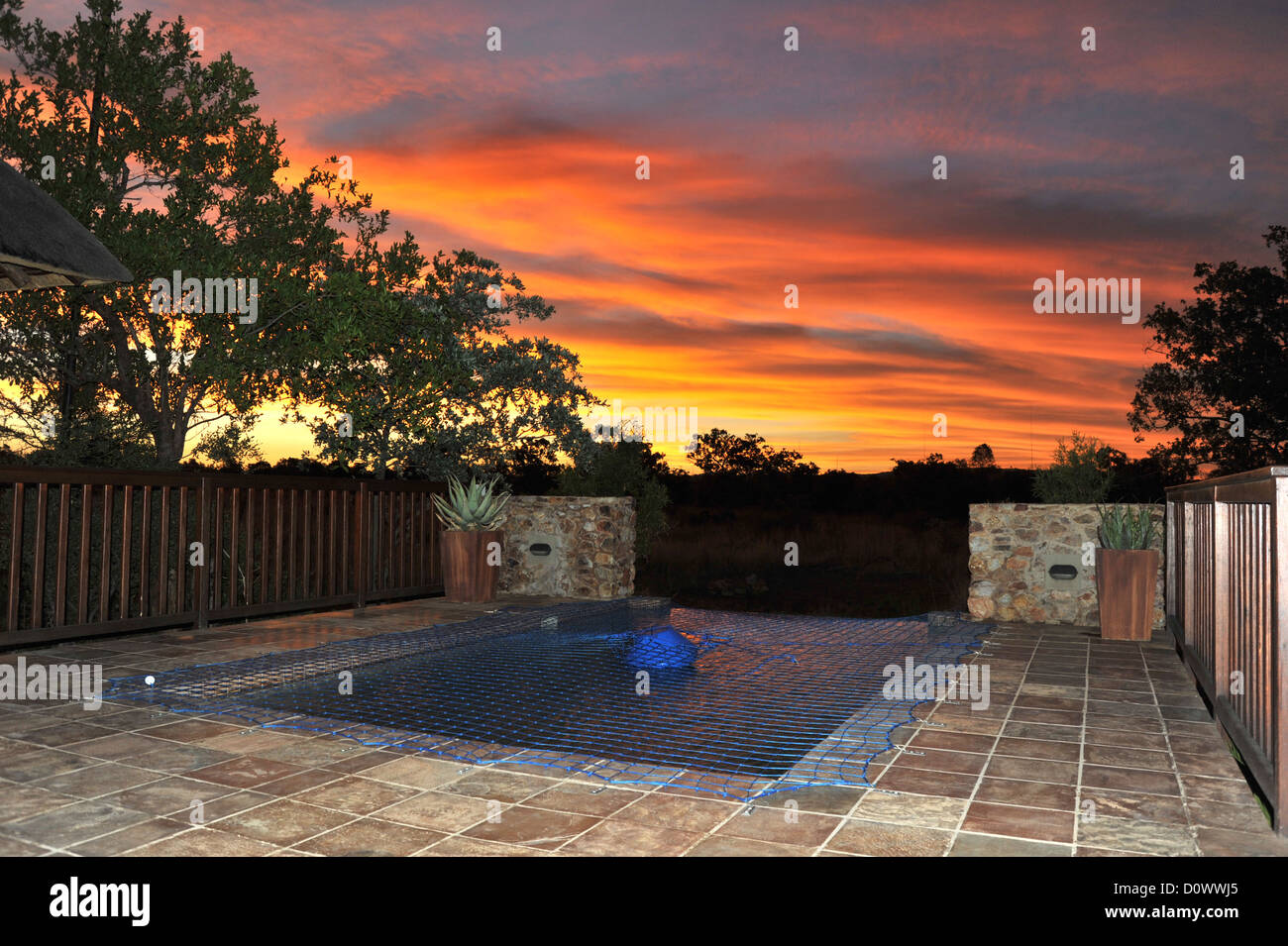 A private swimming pool with a dramatic South African sunset behind it ...