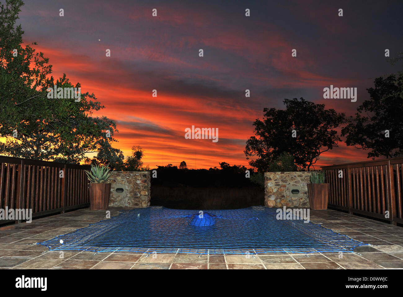 A private swimming pool with a dramatic South African sunset behind it ...