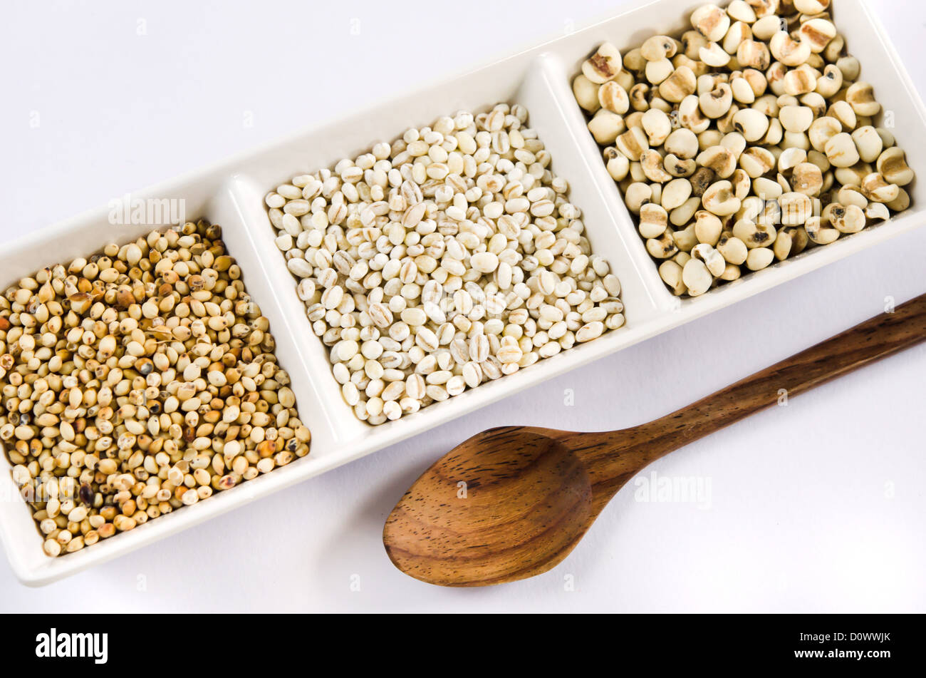 job's tears , barley and millet grains on white bowl and wooden spoon ...
