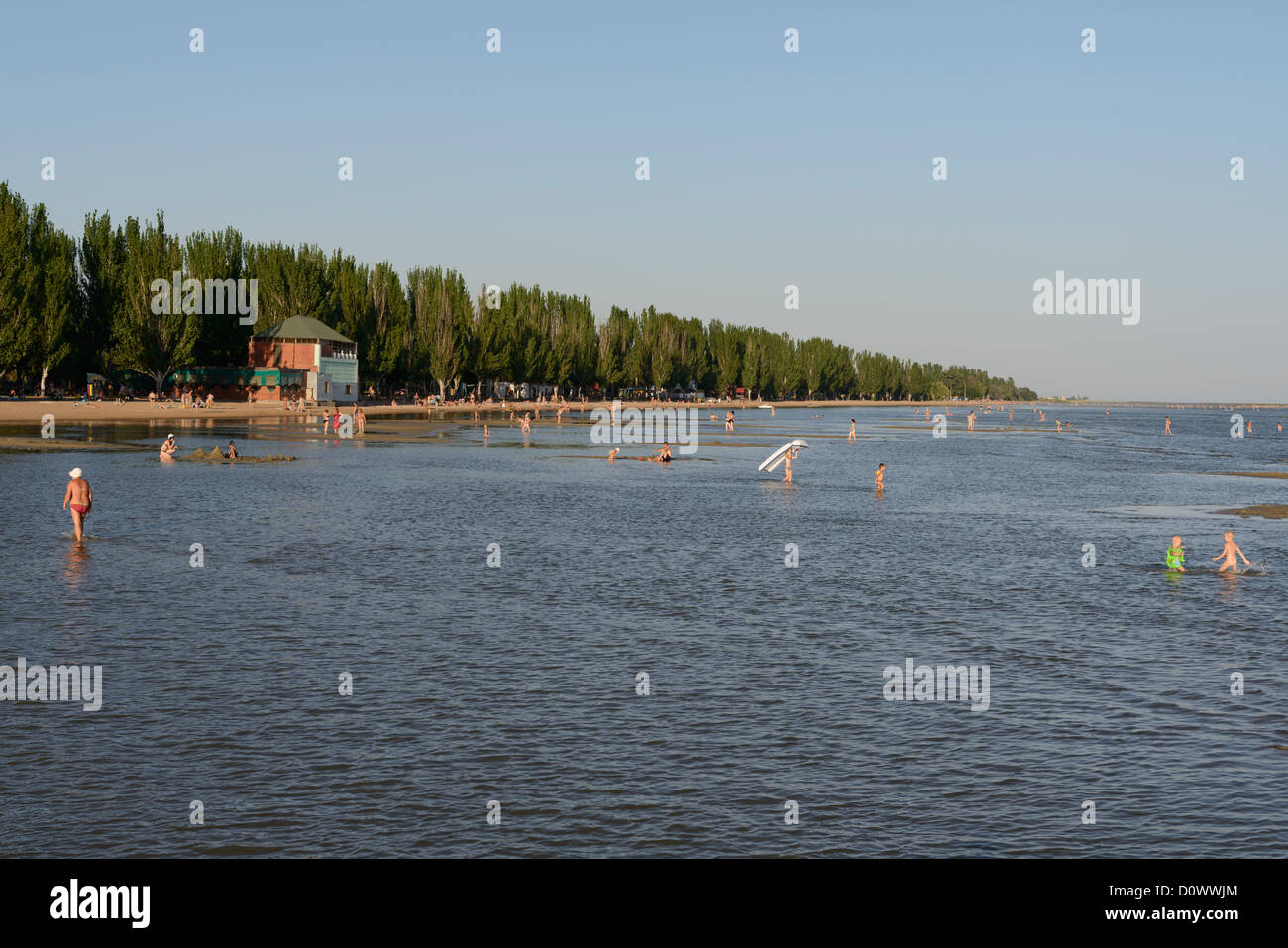 Lots of people bathing on the beach at sunset Stock Photo - Alamy