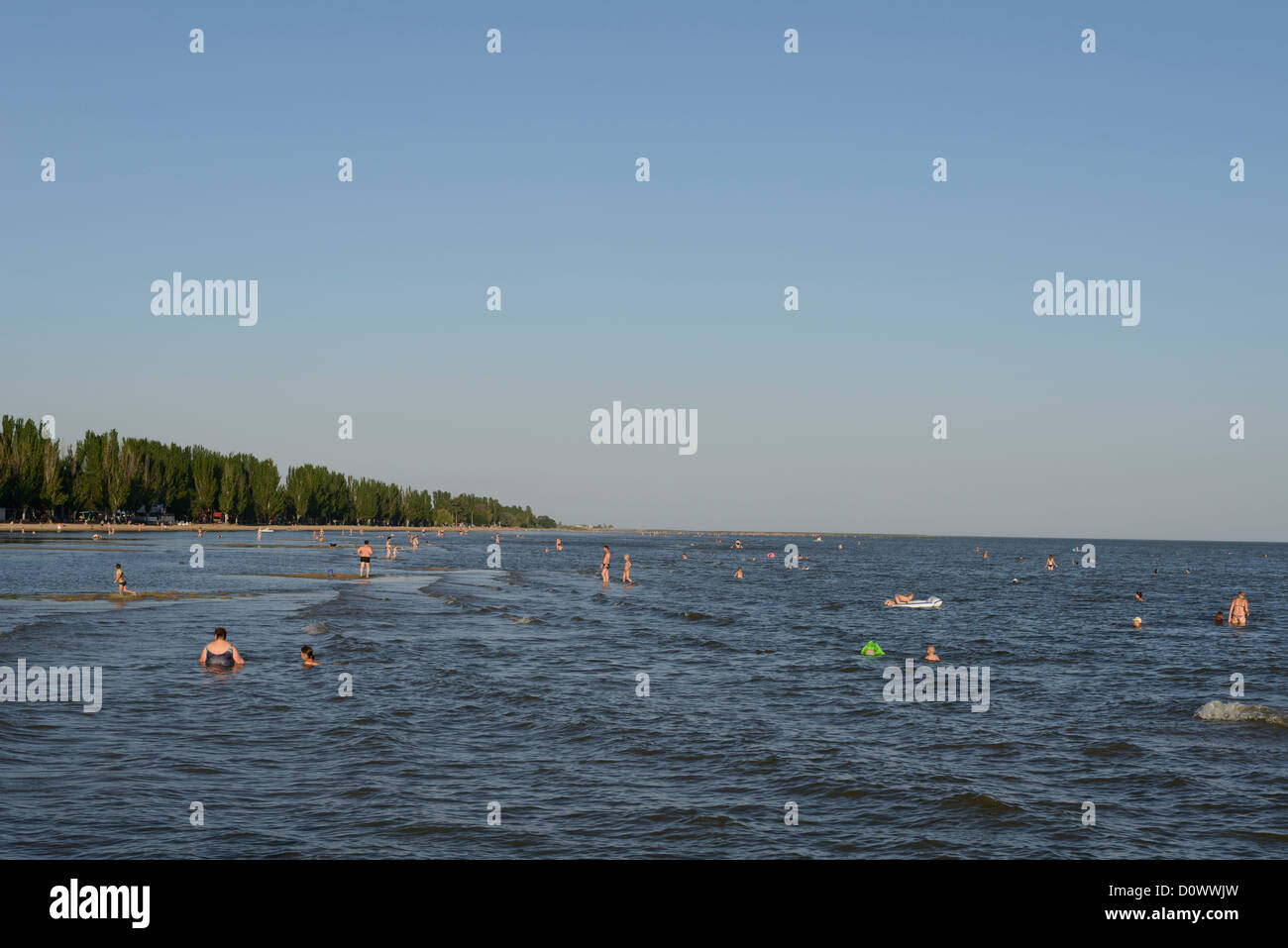 Lots of people bathing on the beach at sunset Stock Photo - Alamy