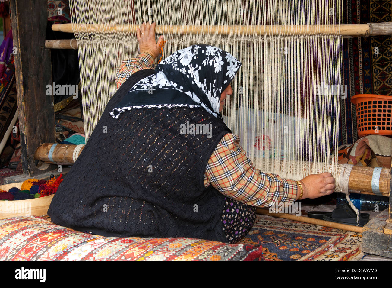 Female carpet weaver sitting at a traditional hand loom, Goreme ...