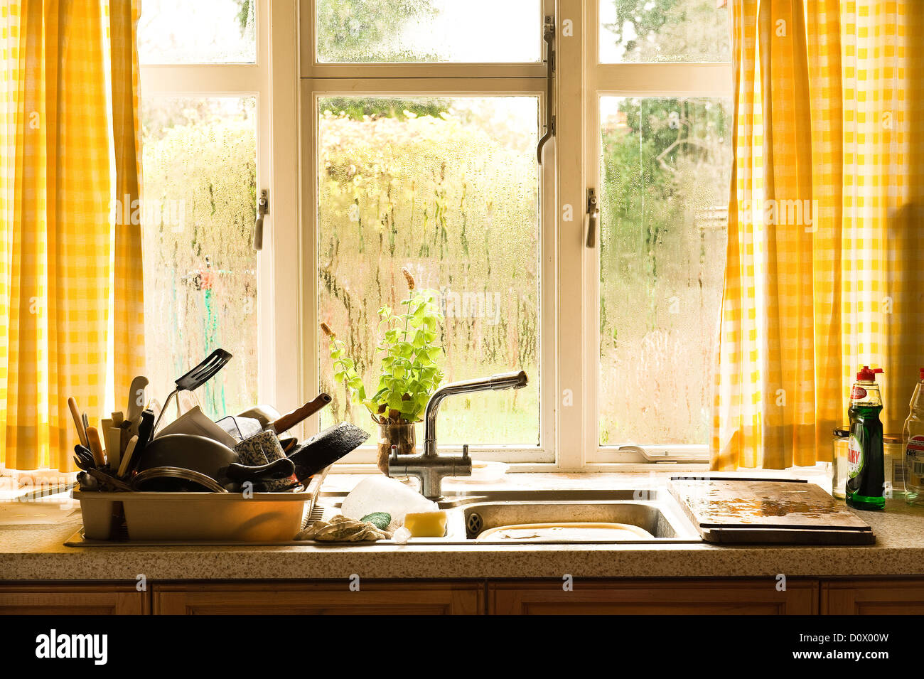 pile of washing up chore for an old age pensioner with condensation on ...