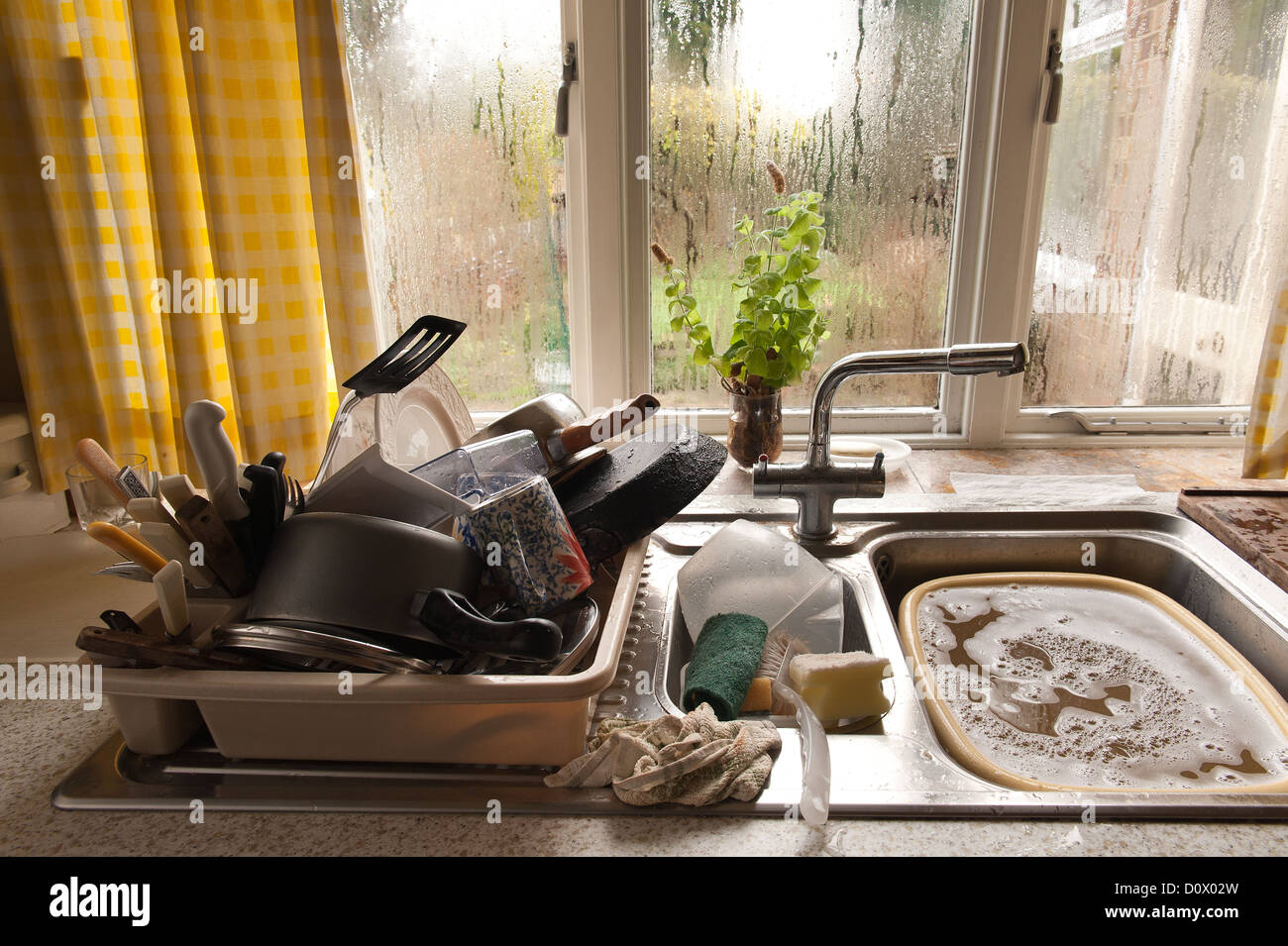 pile of washing up chore for an old age pensioner with condensation on ...