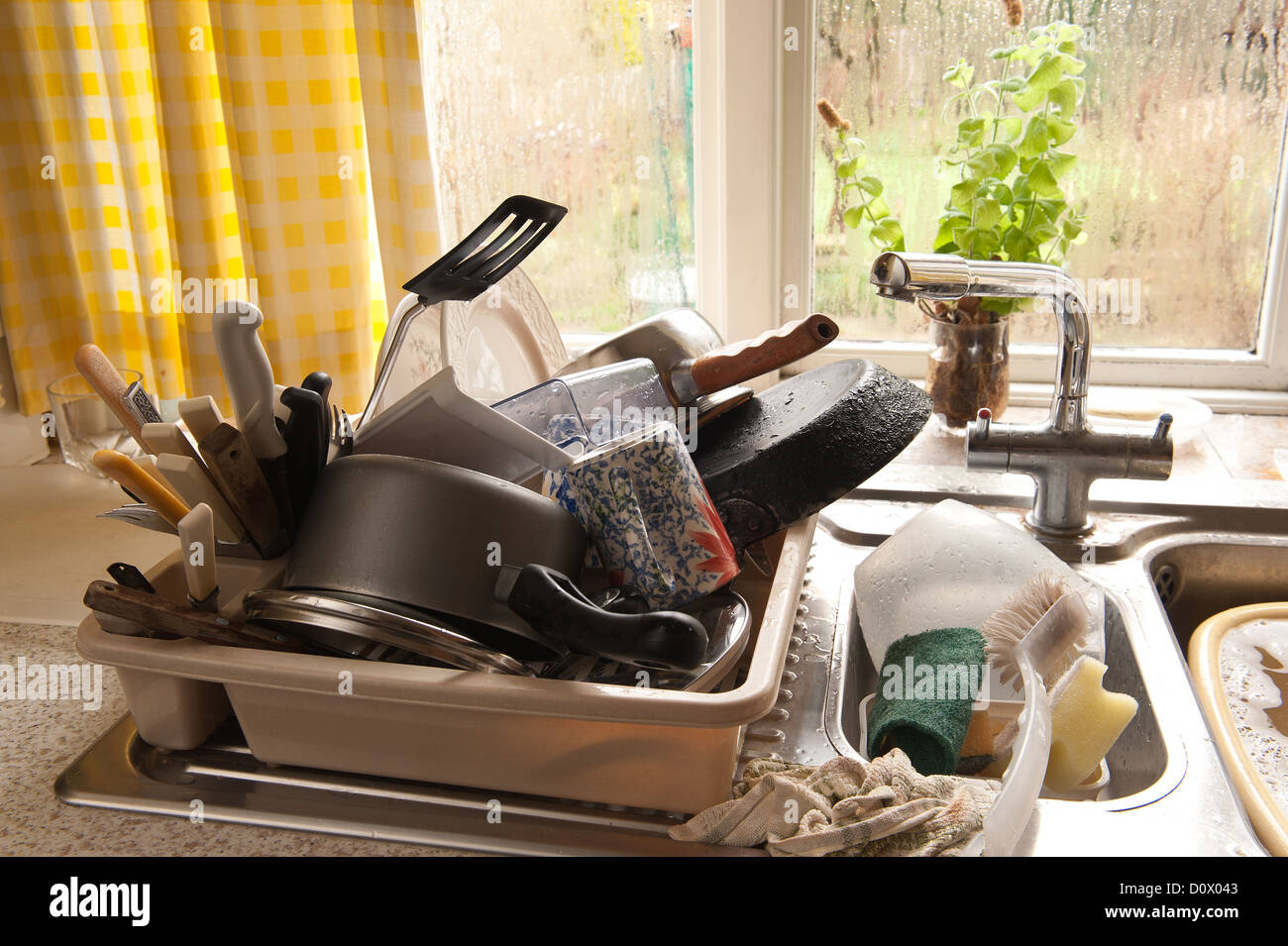 pile of washing up chore for an old age pensioner with condensation on ...