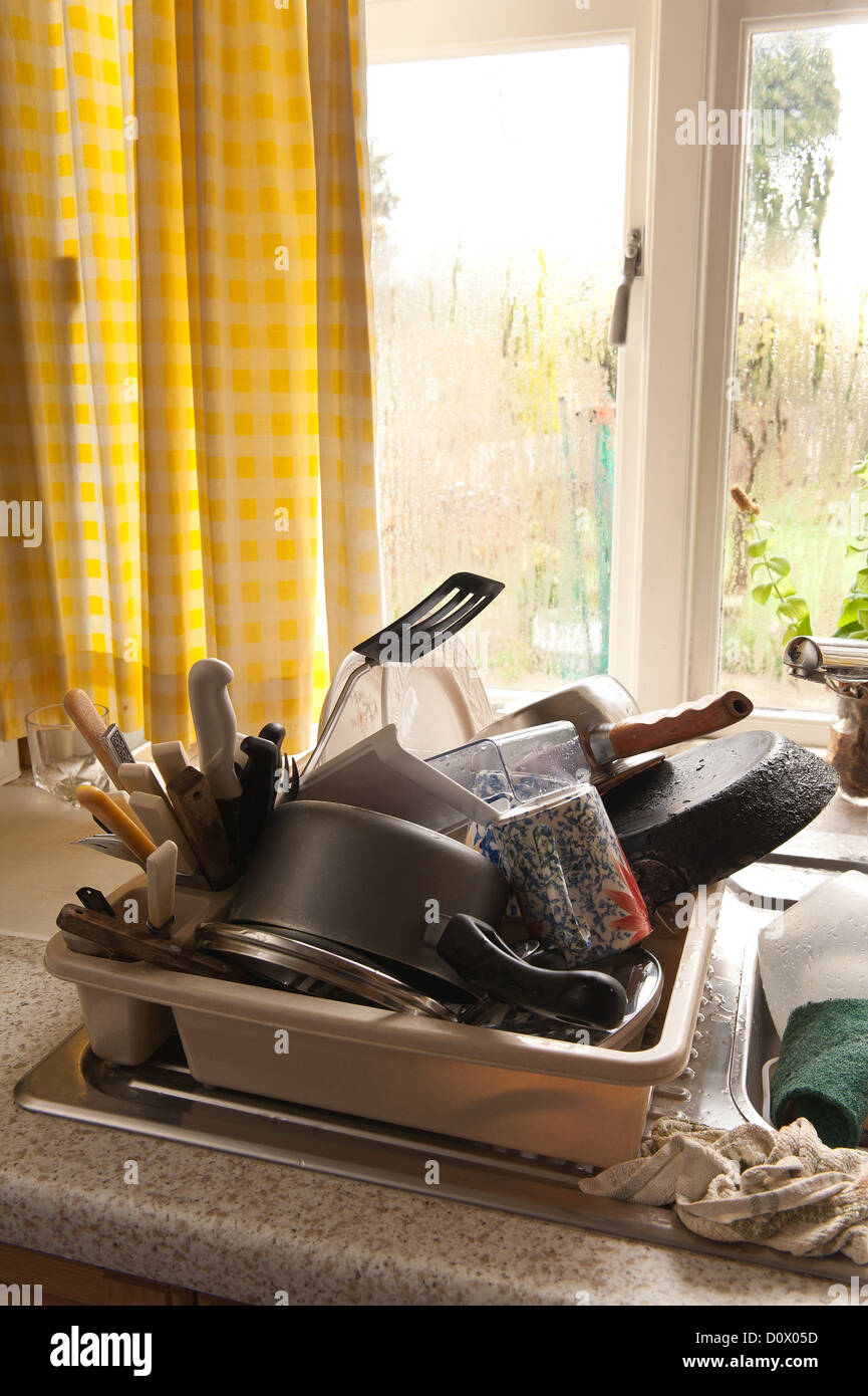 pile of washing up chore for an old age pensioner with condensation on ...